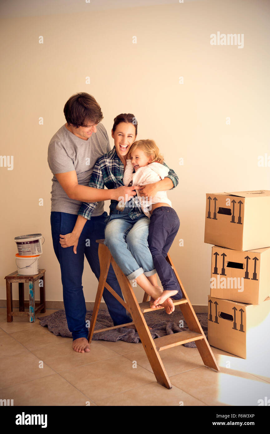 Happy family on step ladder beside cardboard boxes Stock Photo - Alamy