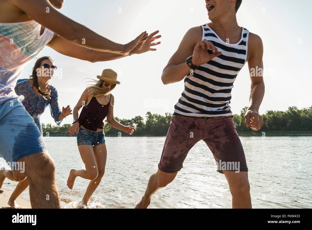Happy friends running at the river Stock Photo - Alamy