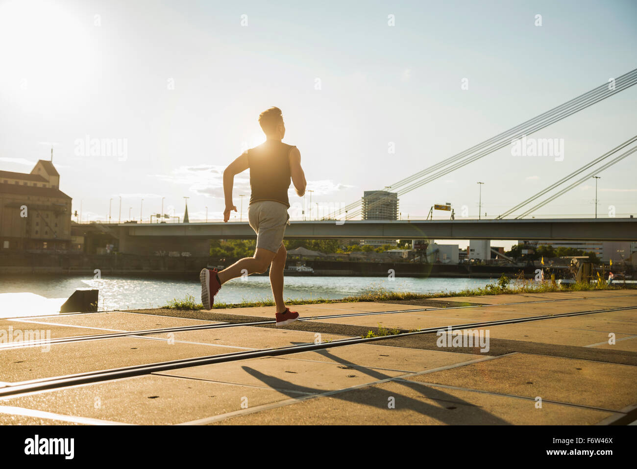 Young man running by the riverside Stock Photo - Alamy