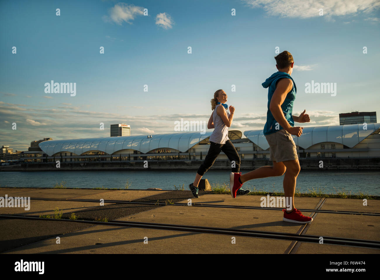 Young couple running by the riverside Stock Photo - Alamy