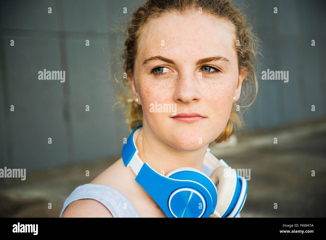 Teenage girl wearing headphones looking around Stock Photo - Alamy