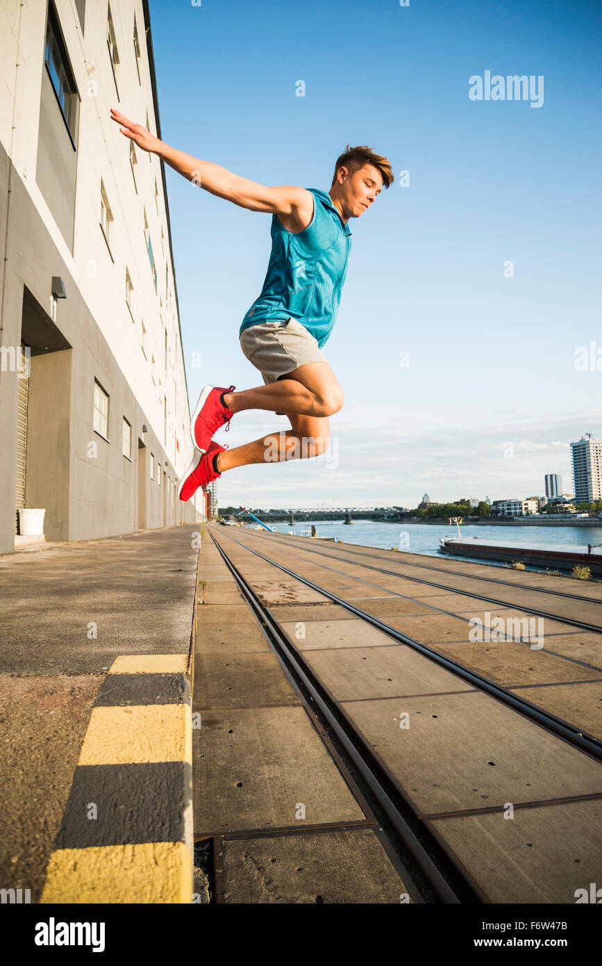 Young man jumping by the riverside Stock Photo - Alamy