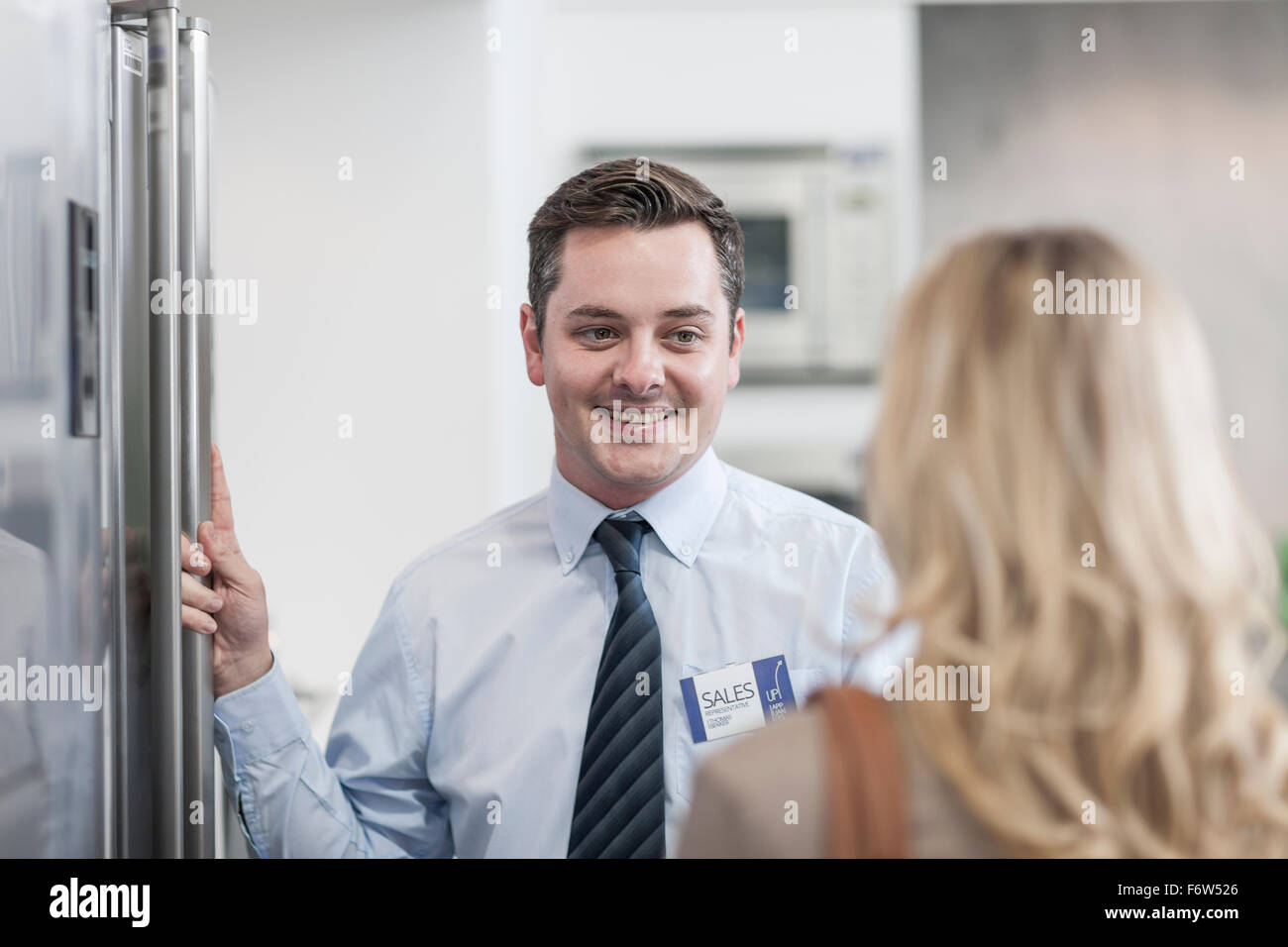 Shop assistant smiling at customer Stock Photo - Alamy