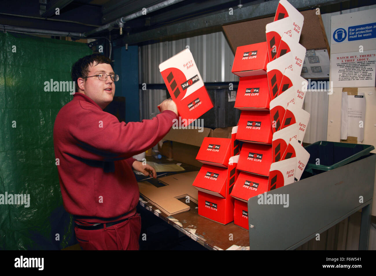 Man with learning disability working in factory assembling cardboard ...