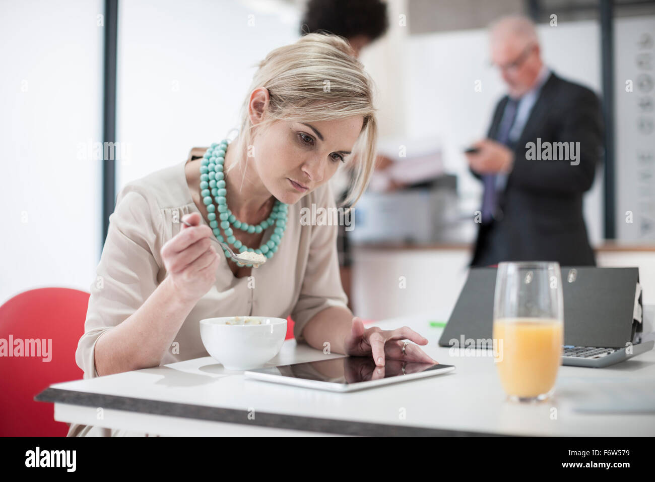Woman eating breakfast in office Stock Photo - Alamy