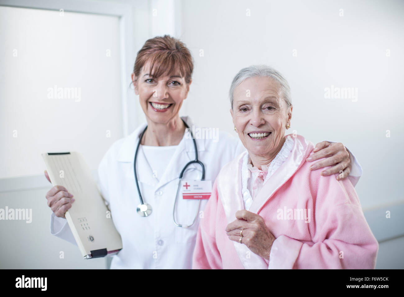 Portrait of doctor and smiling elderly patient in hospital Stock Photo ...