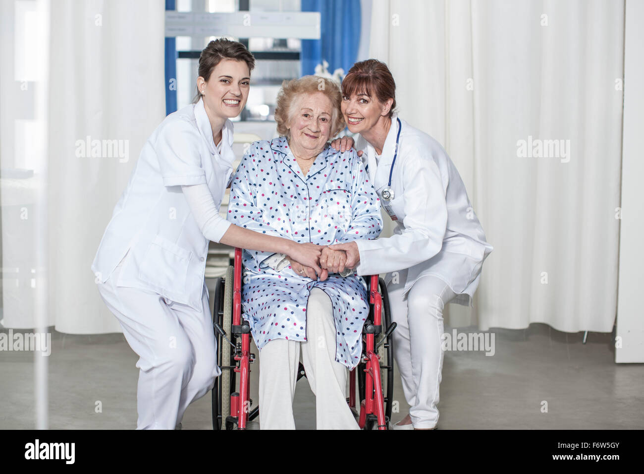 Doctor and nurse caring for elderly patient in wheelchair Stock Photo ...