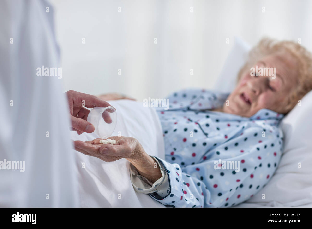 Patient lying in hospital bed receiving medication Stock Photo - Alamy