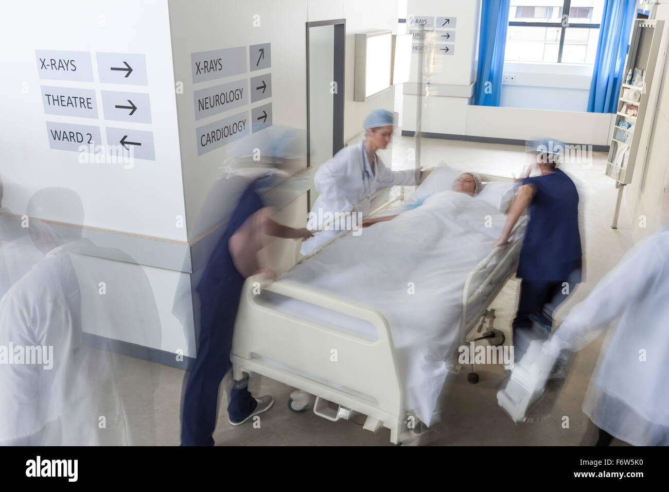 Doctors pushing a bed with patient Stock Photo - Alamy