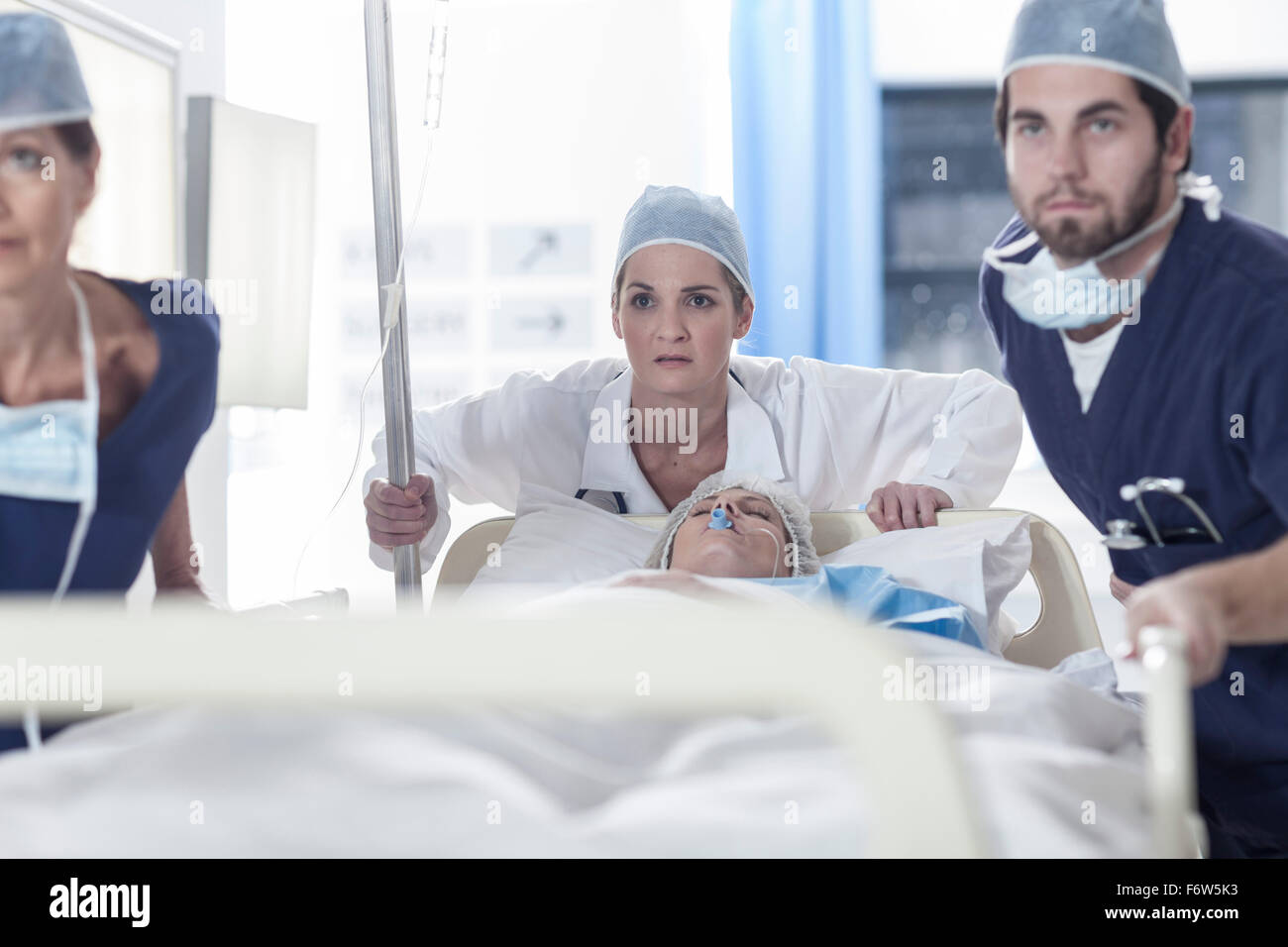 Doctors pushing a bed with patient Stock Photo - Alamy