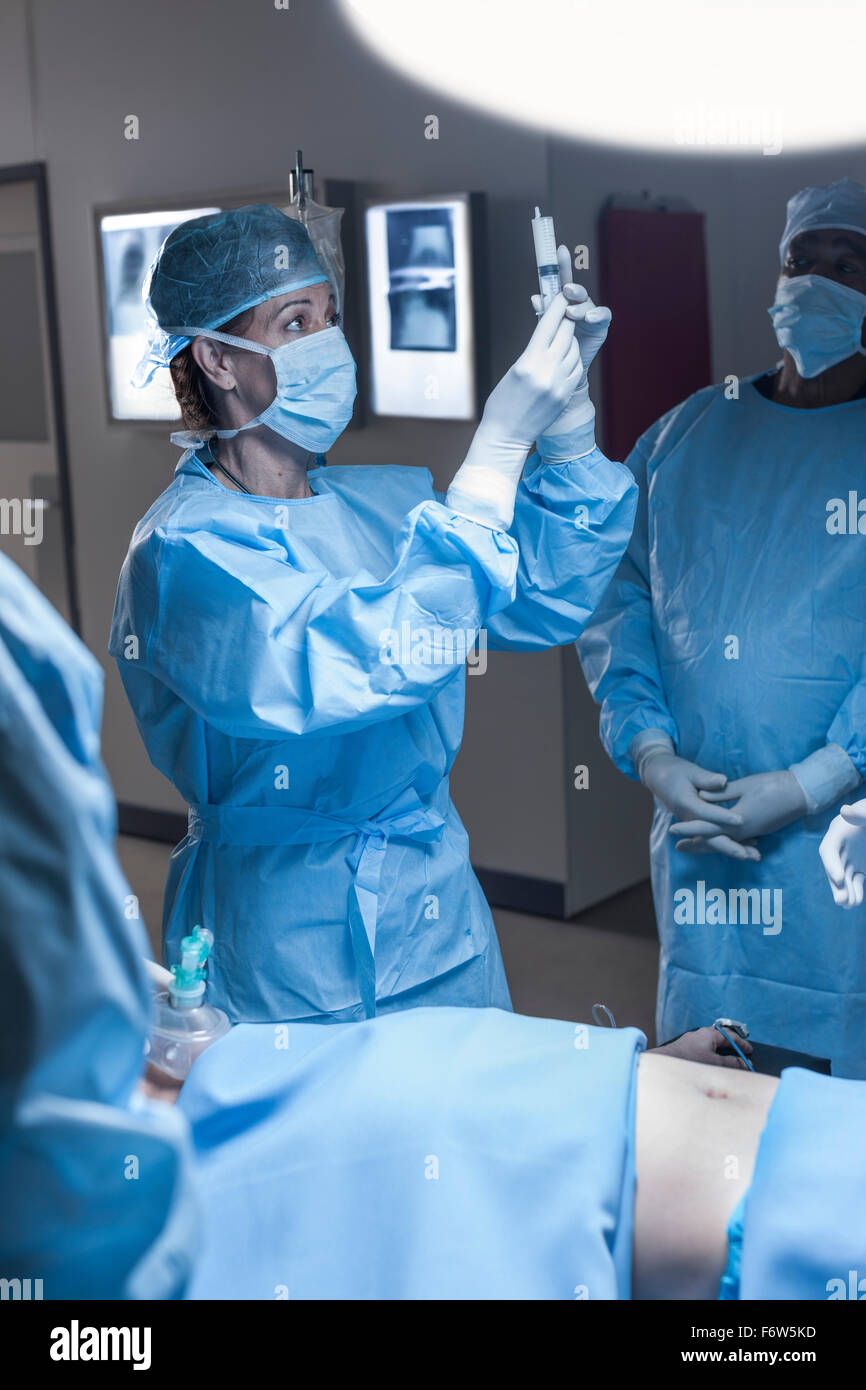 Doctor preparing syringe for patient in operating room Stock Photo - Alamy