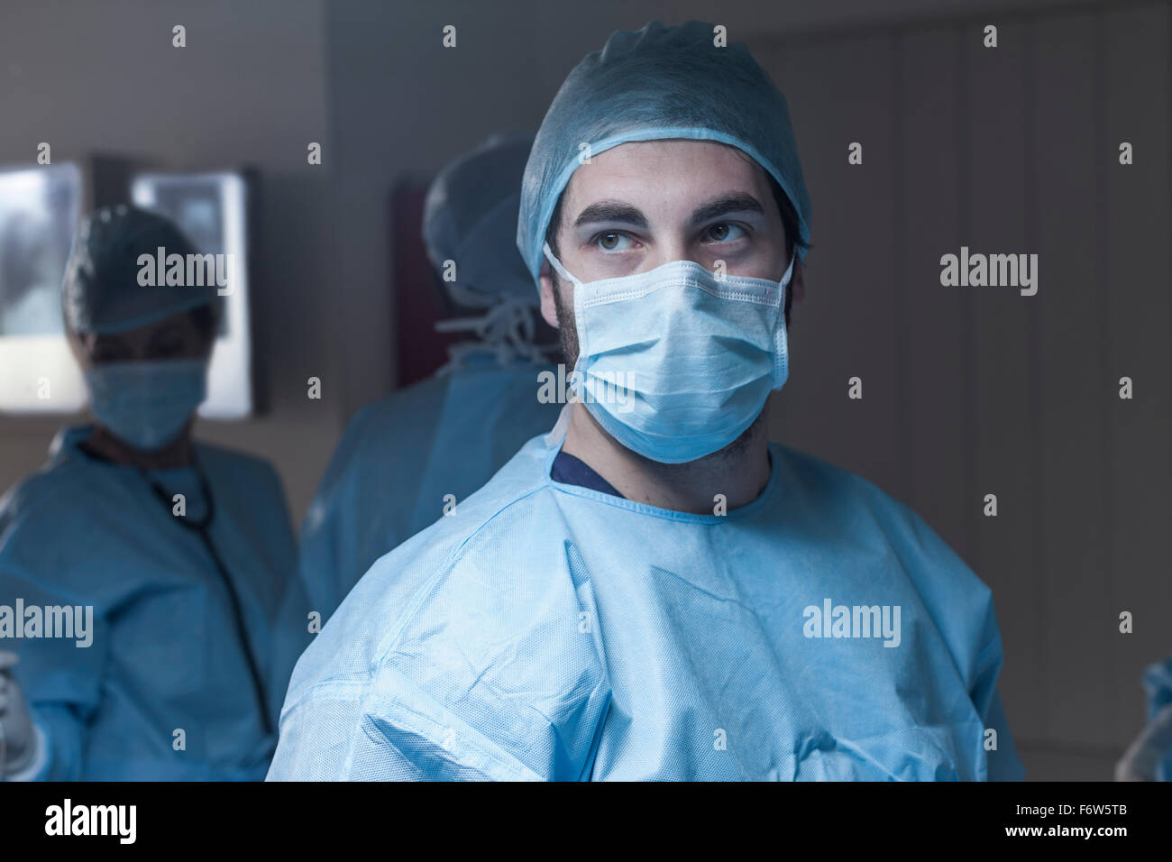 Portrait of surgeon wearing mask with team in background Stock Photo ...