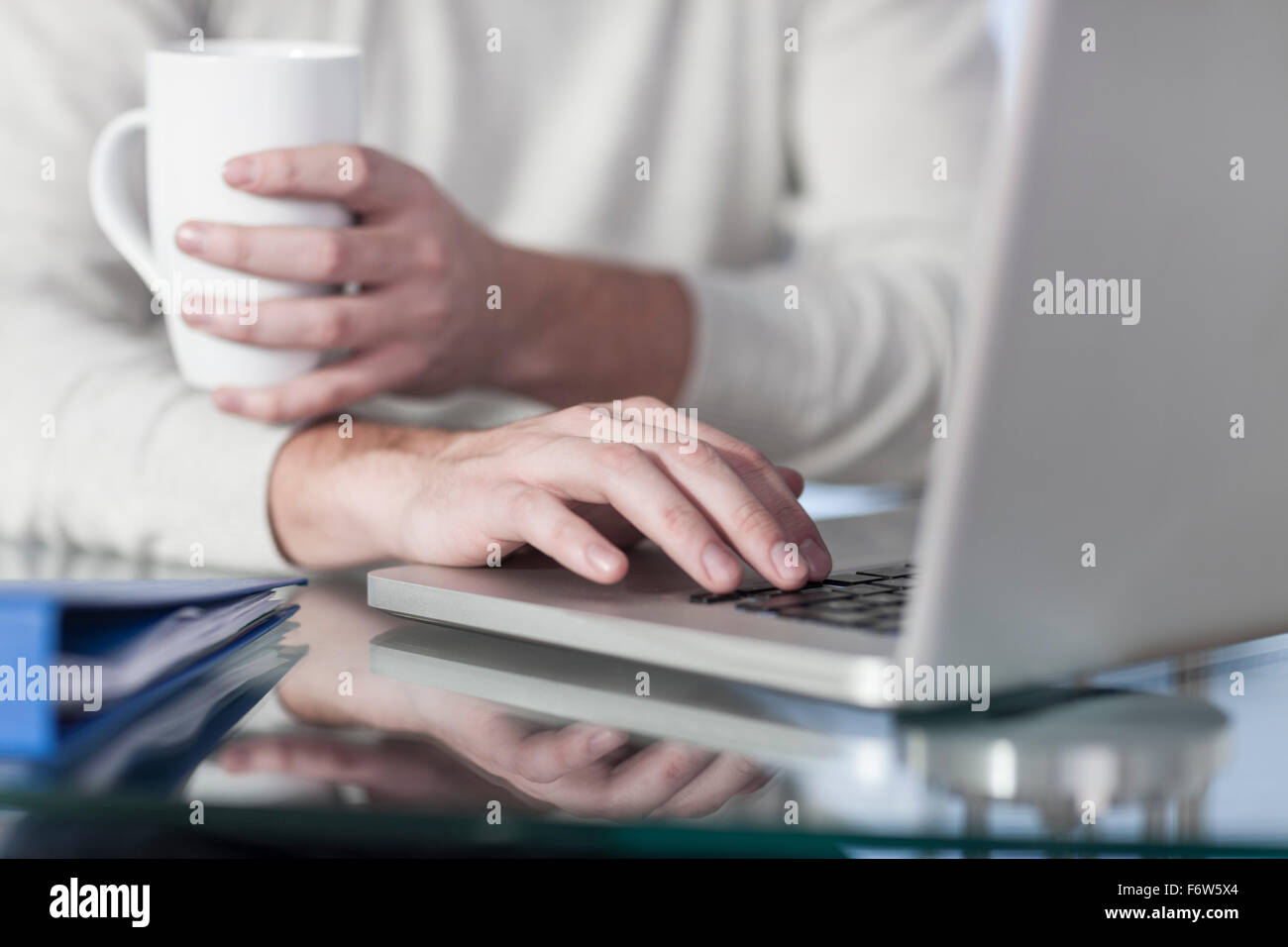 Close-up of person at desk working at laptop Stock Photo - Alamy