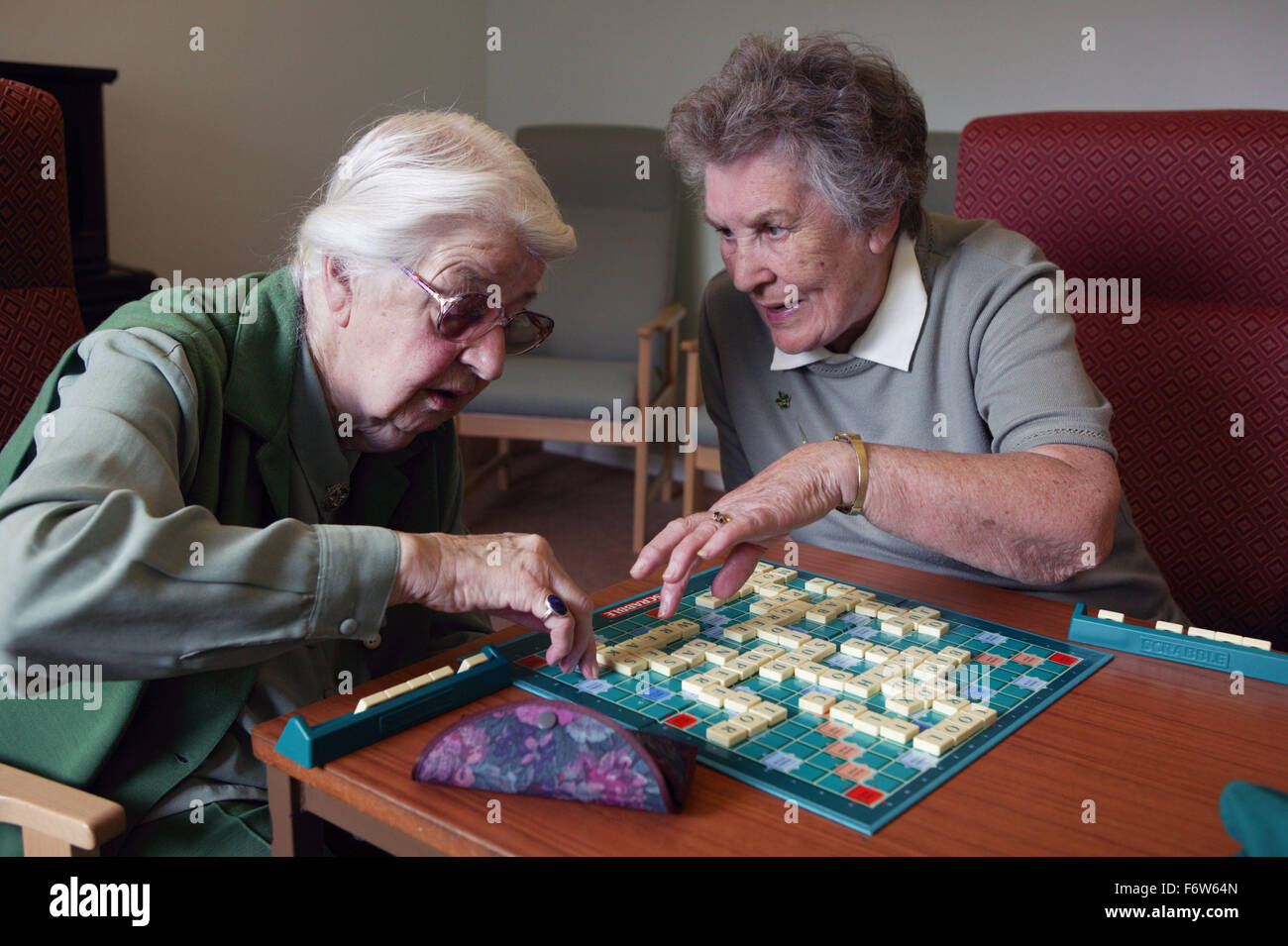 Two elderly women playing game of scrabble at day centre Stock Photo ...