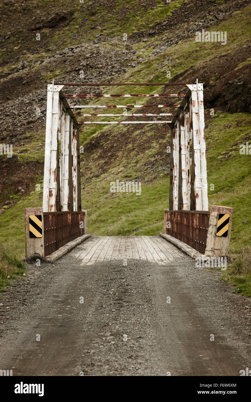 Old rusty Steel bridge and rural road against mountain background in ...