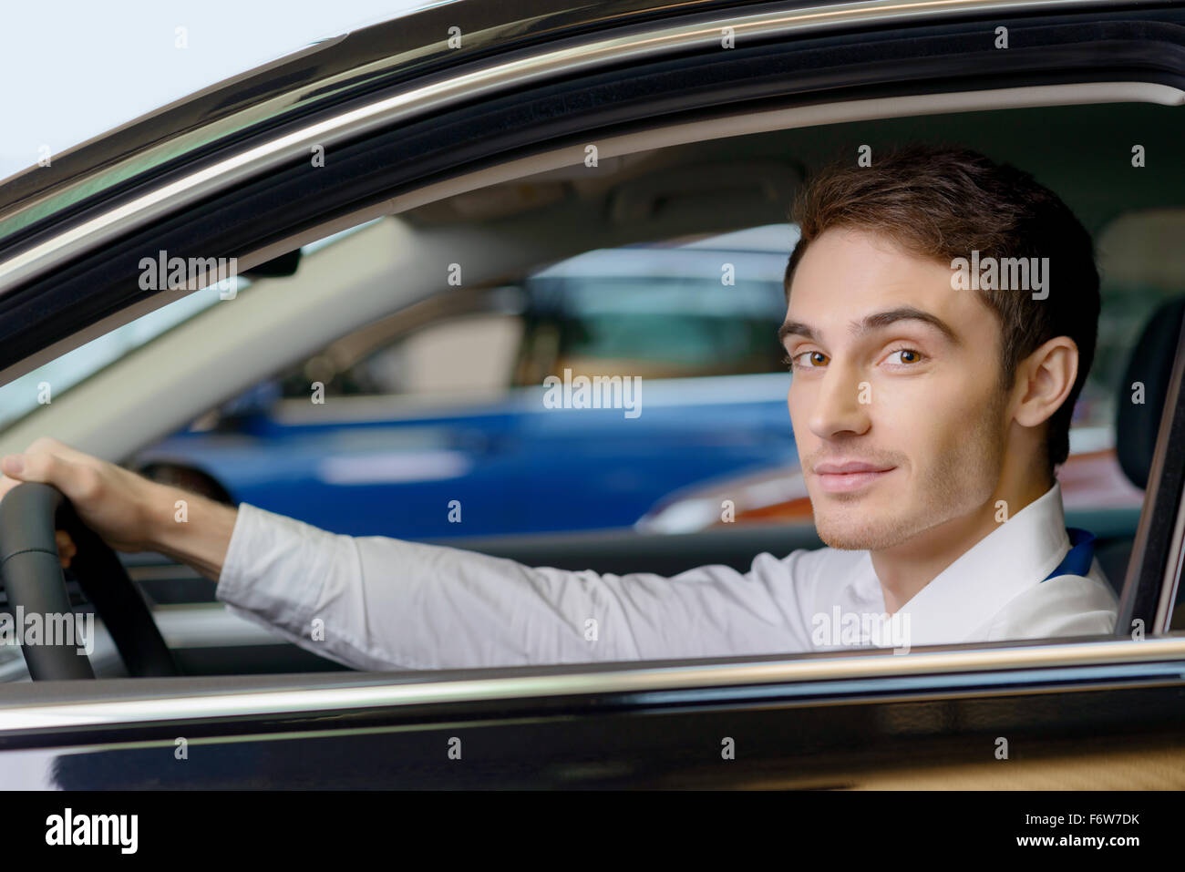 Handsome man sits at drivers seat Stock Photo - Alamy