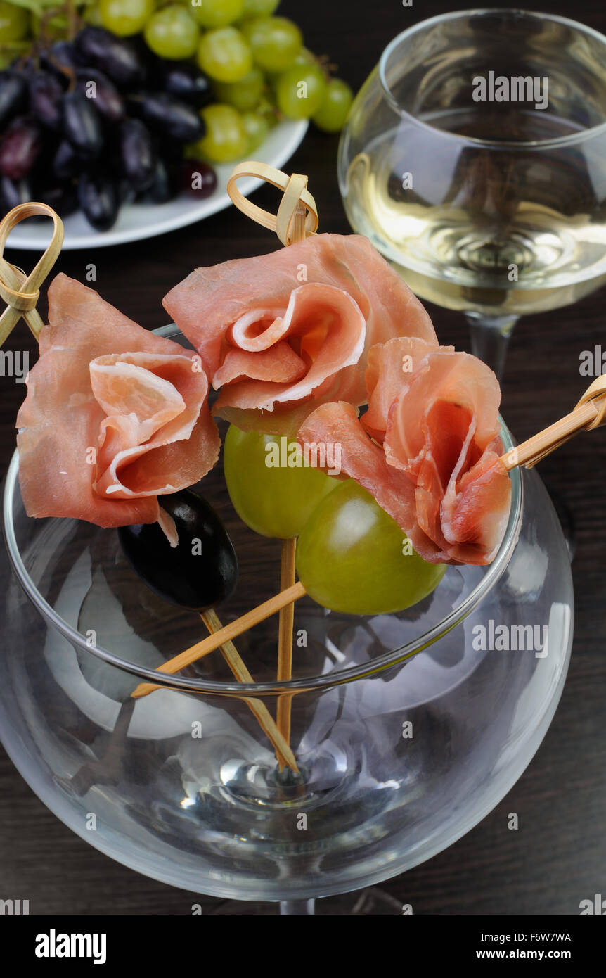 Appetizer of ham with grapes on a skewer in the glass Stock Photo - Alamy
