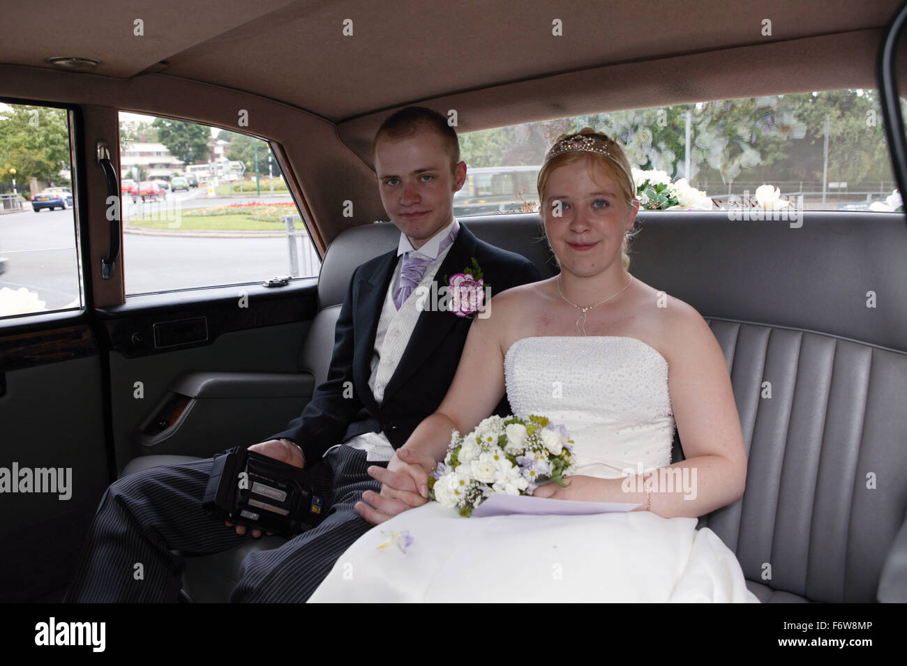 Bride and groom sitting in back of chauffeur driven car Stock Photo - Alamy