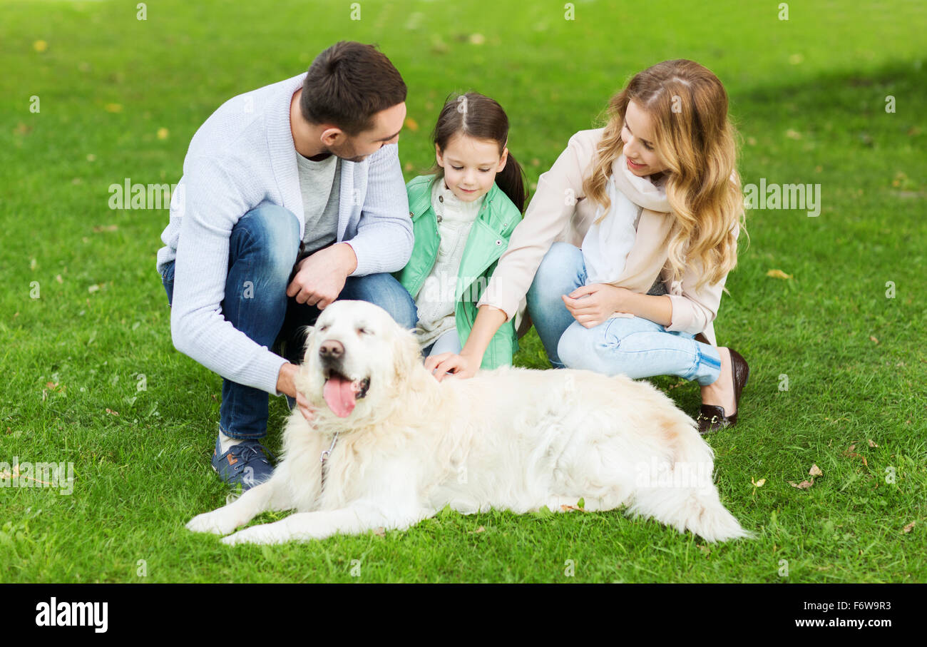 happy family with labrador retriever dog in park Stock Photo - Alamy