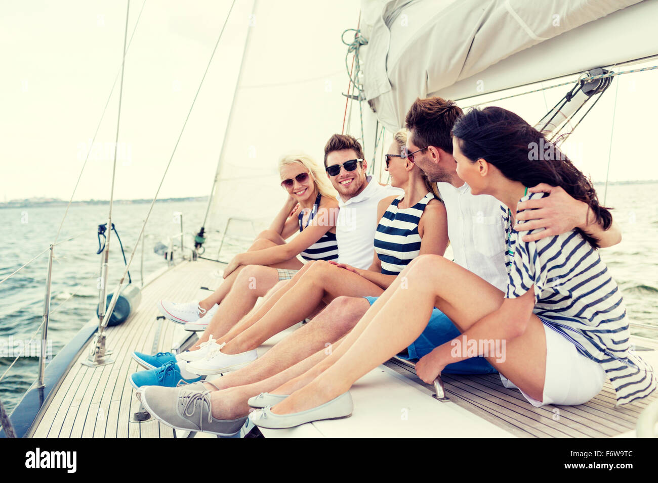 smiling friends sitting on yacht deck Stock Photo - Alamy