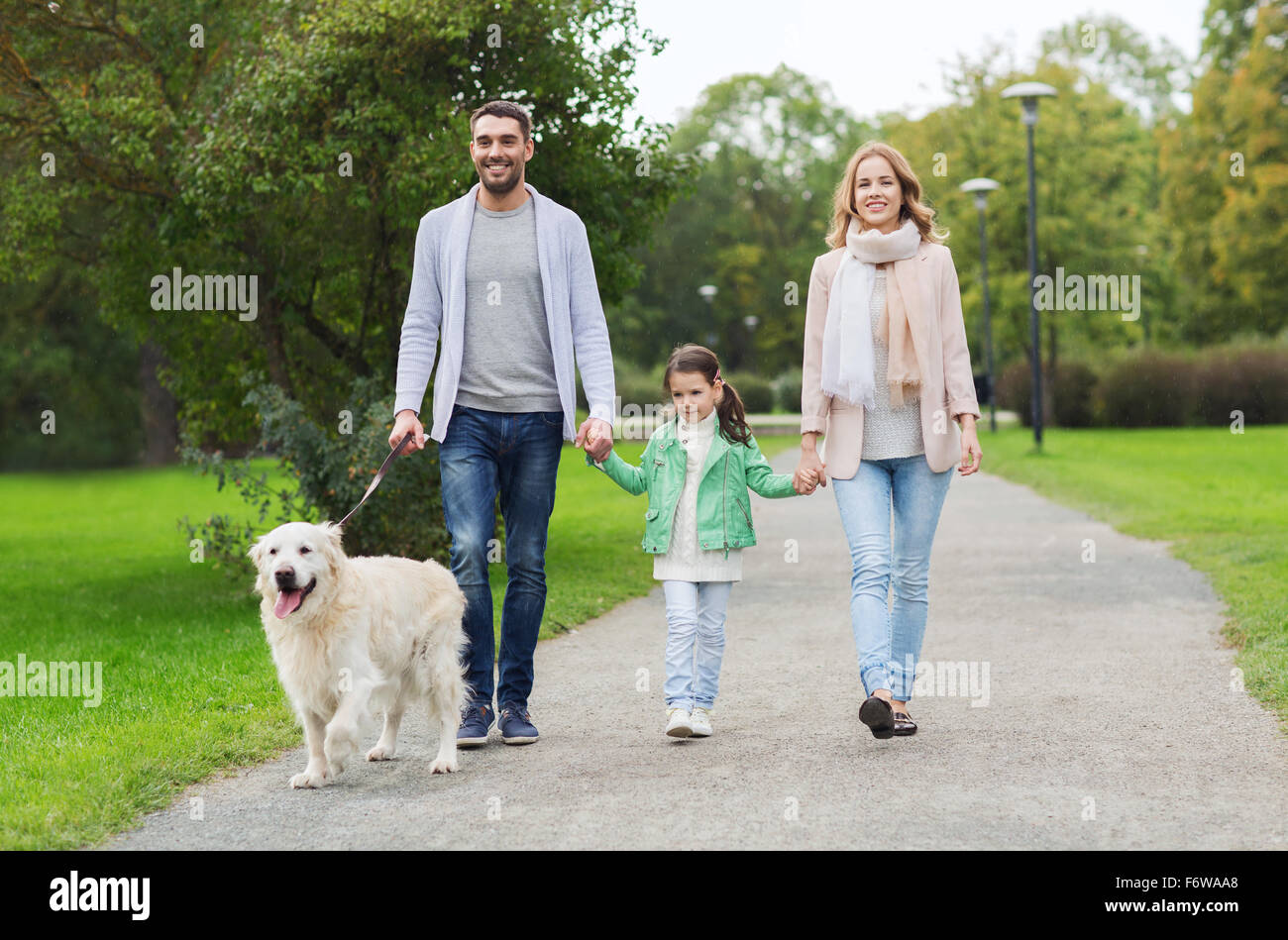 happy family with labrador retriever dog in park Stock Photo - Alamy