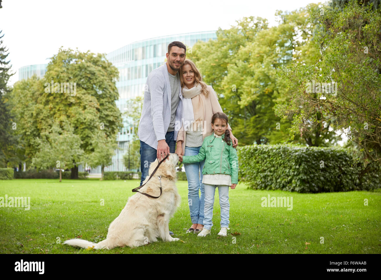 happy family with labrador retriever dog in park Stock Photo - Alamy