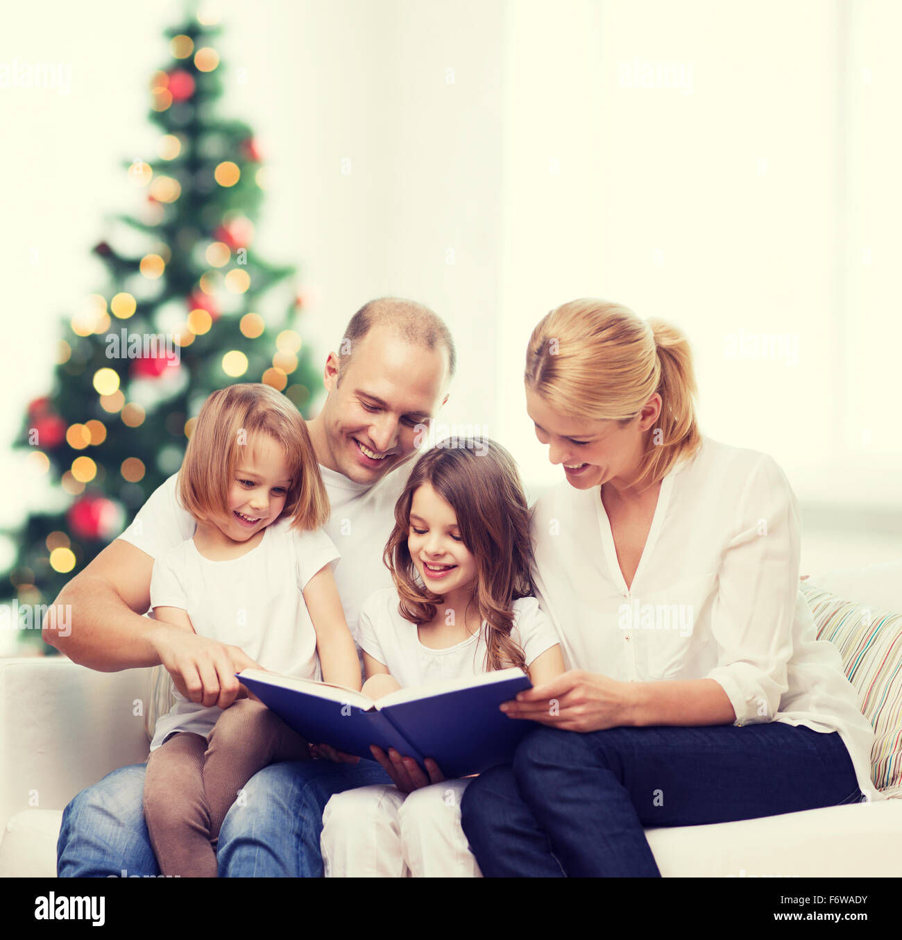 happy family with book at home Stock Photo - Alamy