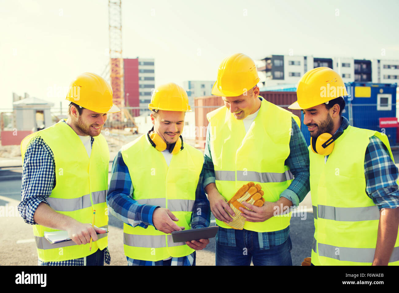 group of smiling builders with tablet pc outdoors Stock Photo - Alamy