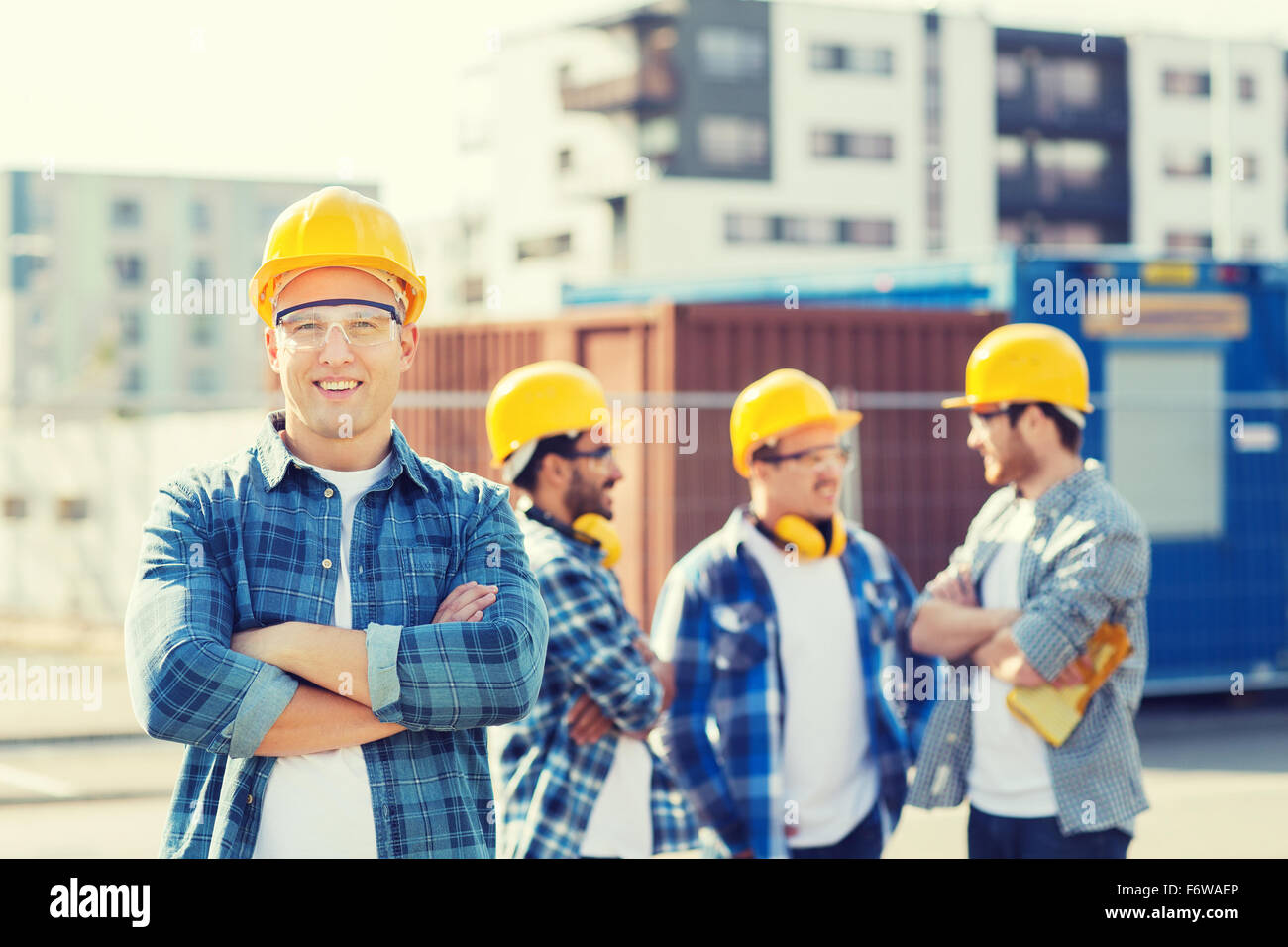 group of smiling builders in hardhats outdoors Stock Photo - Alamy