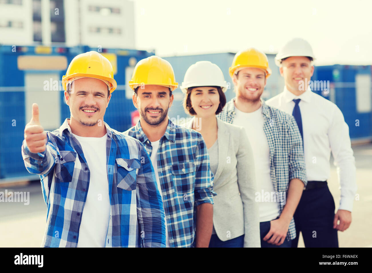 group of smiling builders in hardhats outdoors Stock Photo - Alamy