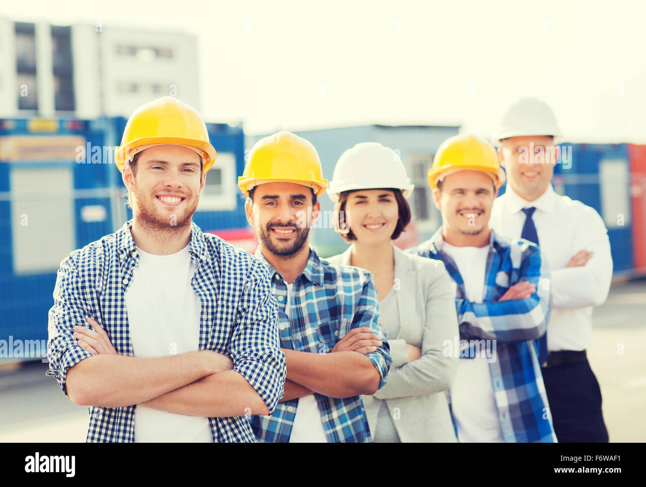 group of smiling builders in hardhats outdoors Stock Photo - Alamy