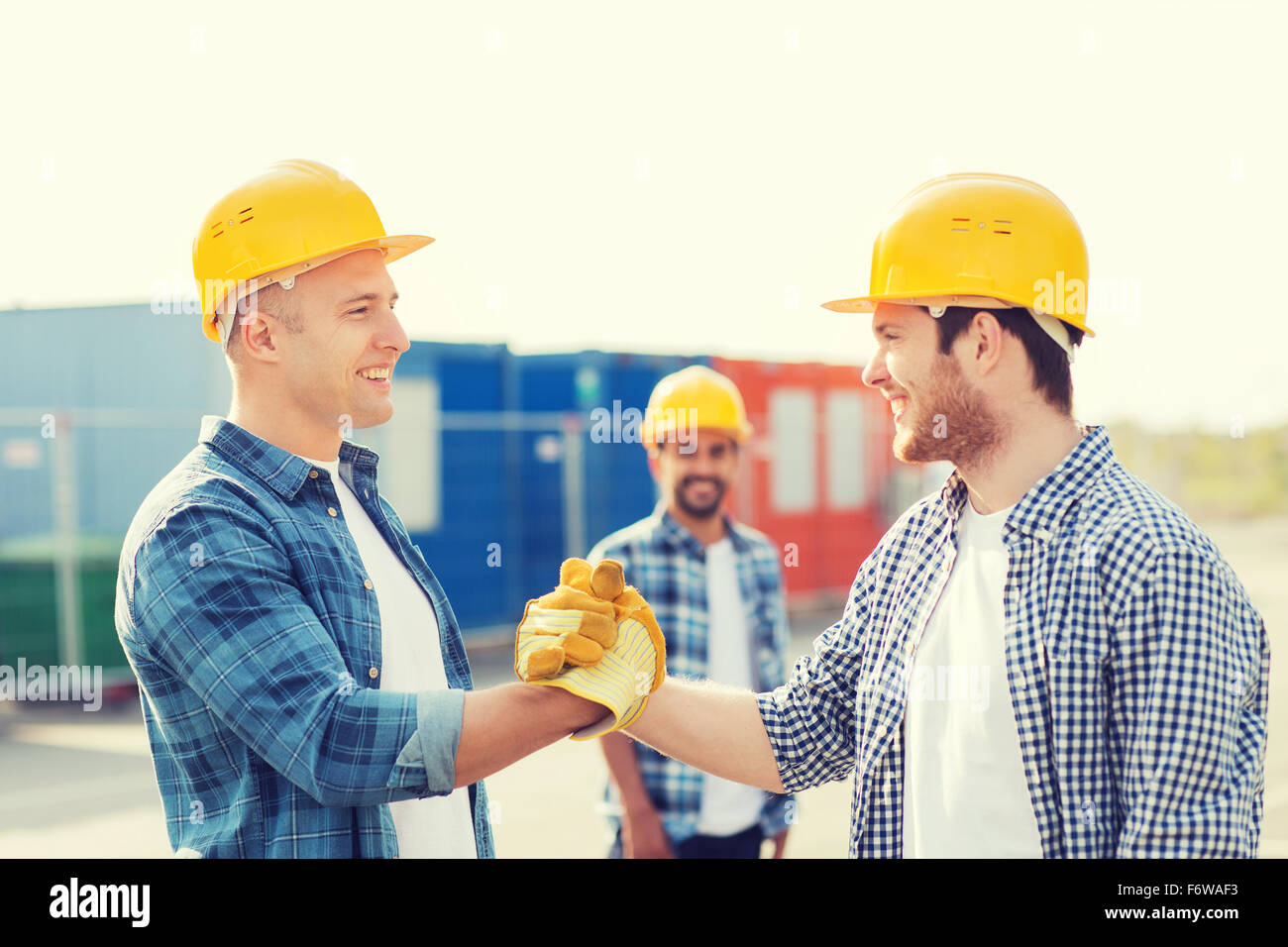 group of smiling builders in hardhats outdoors Stock Photo - Alamy
