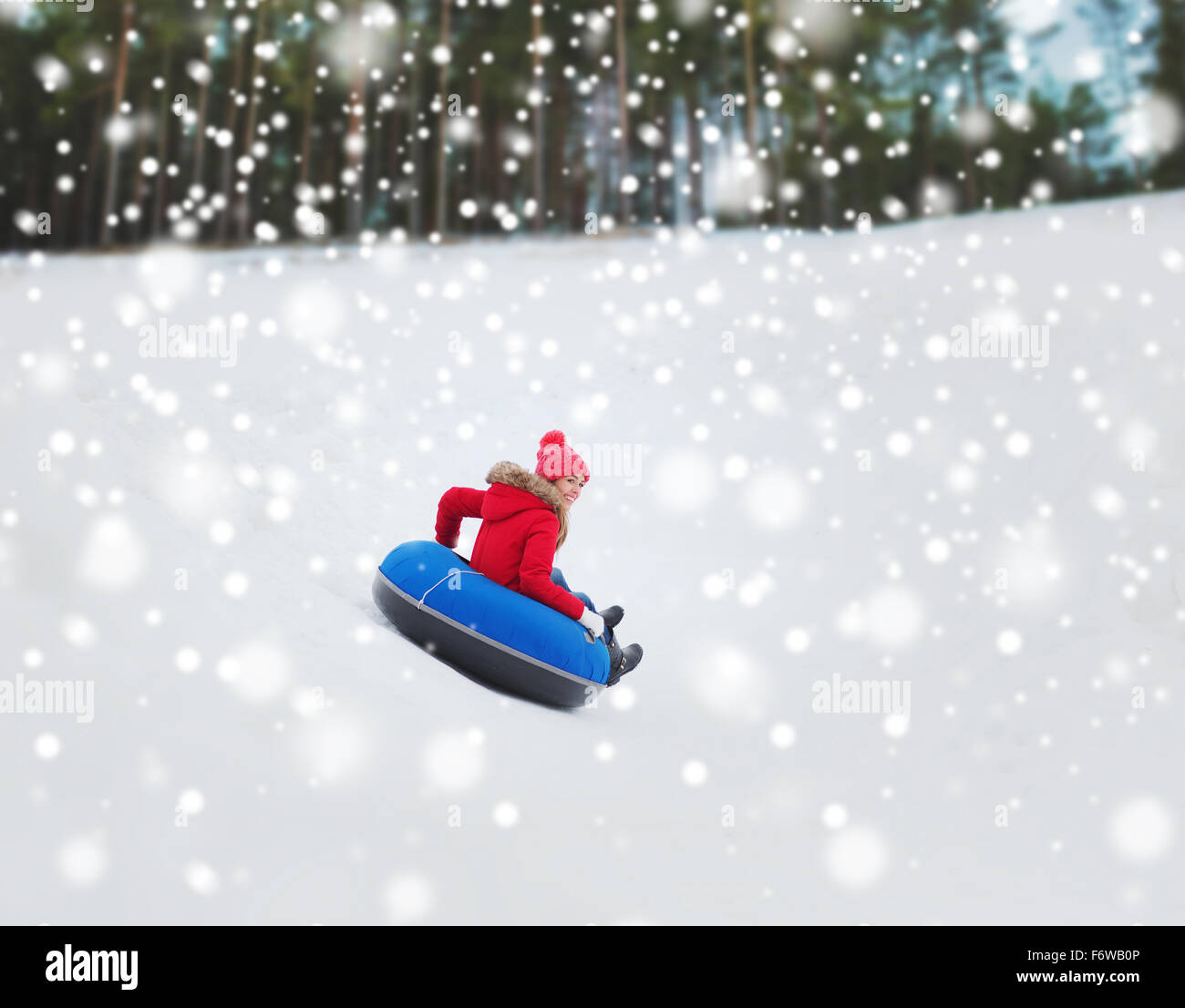 happy teenage girl sliding down on snow tube Stock Photo - Alamy