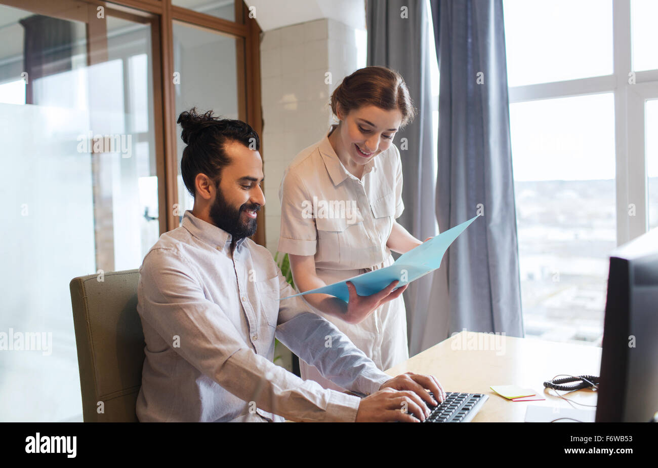 happy creative team with computer in office Stock Photo - Alamy