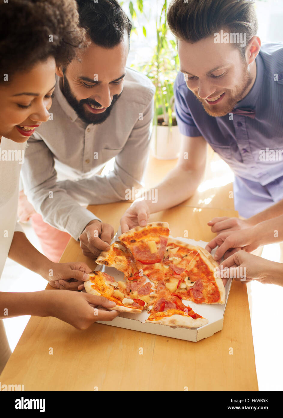 happy business team eating pizza in office Stock Photo - Alamy