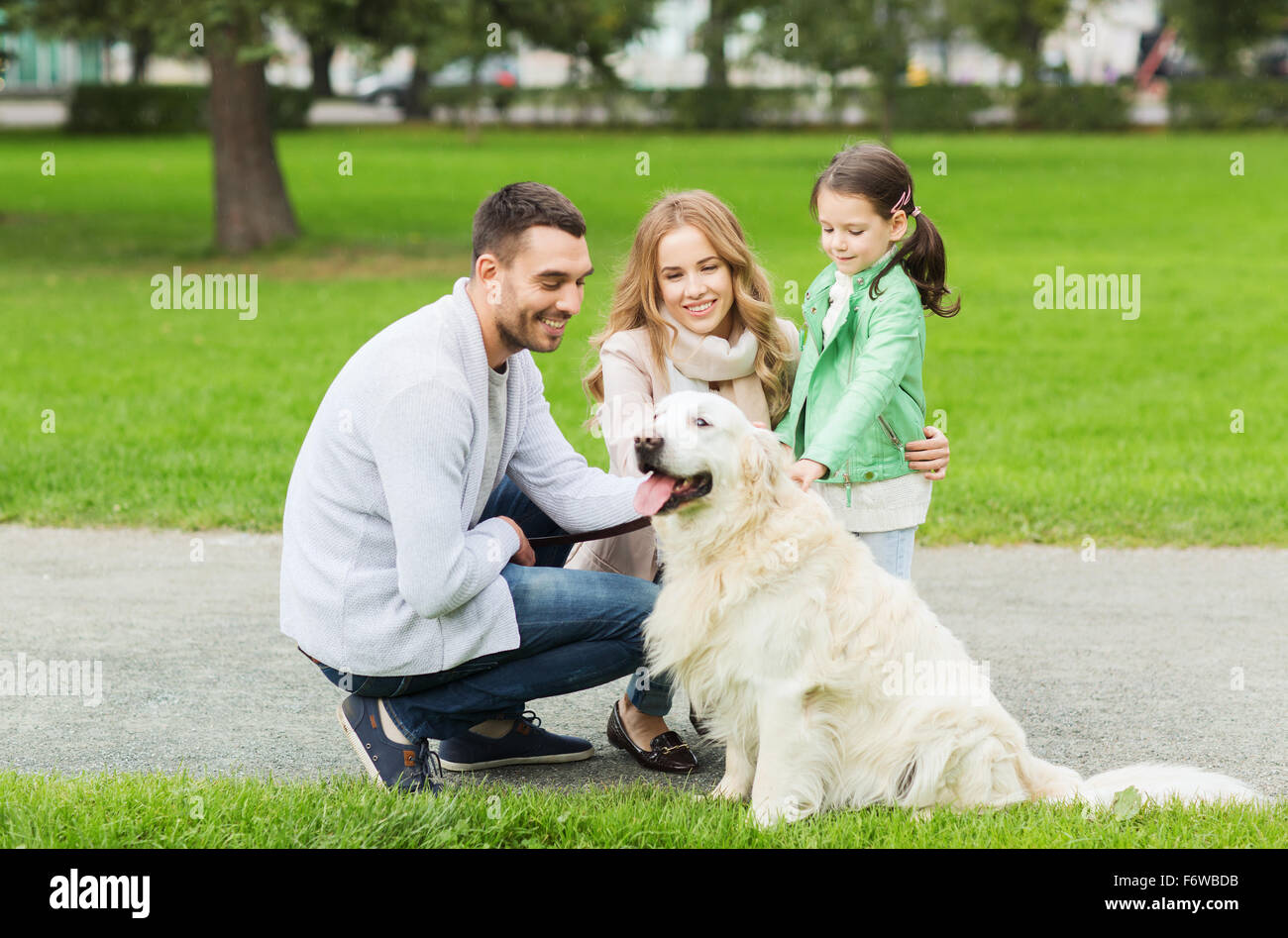 happy family with labrador retriever dog in park Stock Photo - Alamy