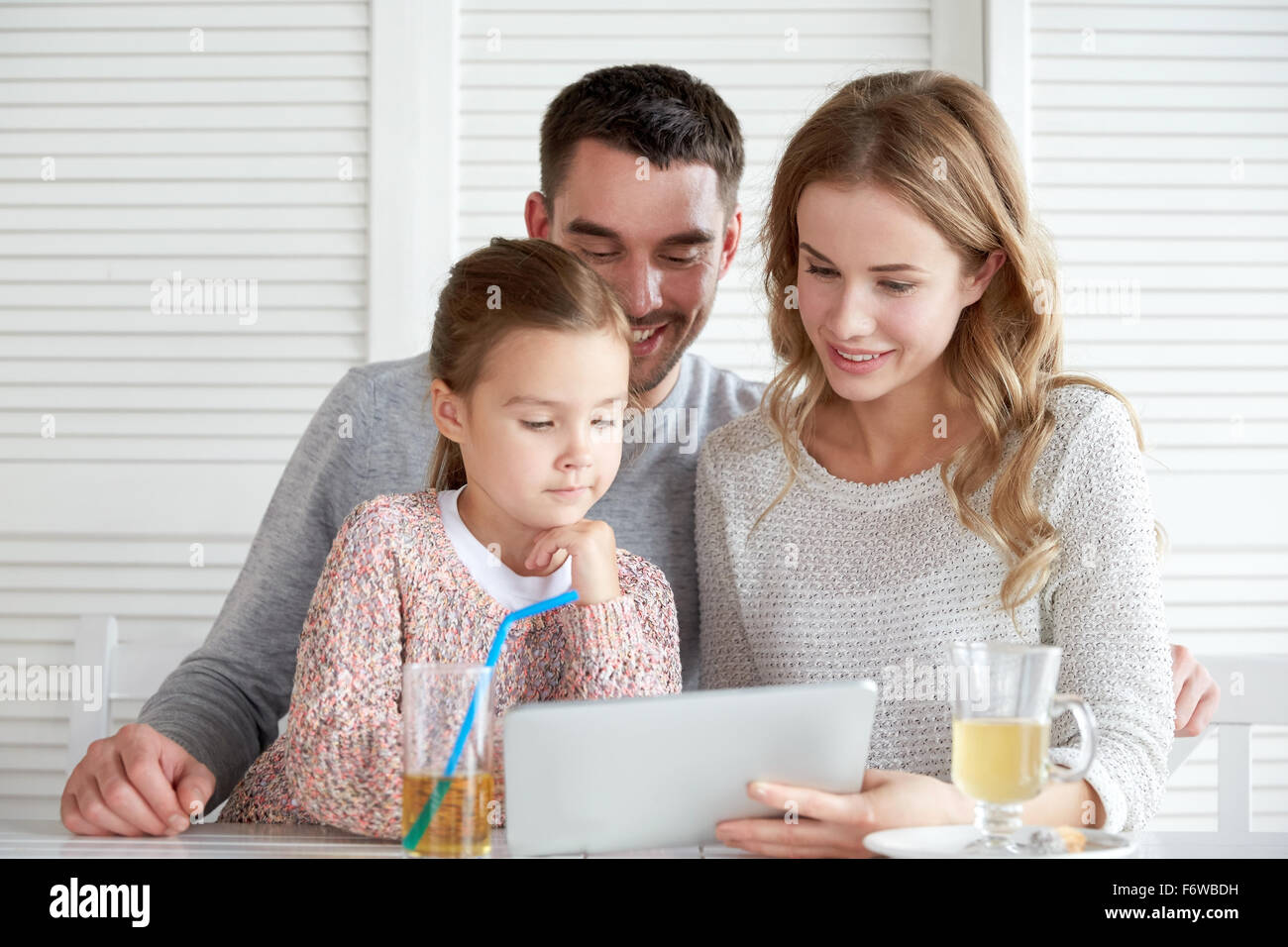 happy family with tablet pc at restaurant Stock Photo - Alamy
