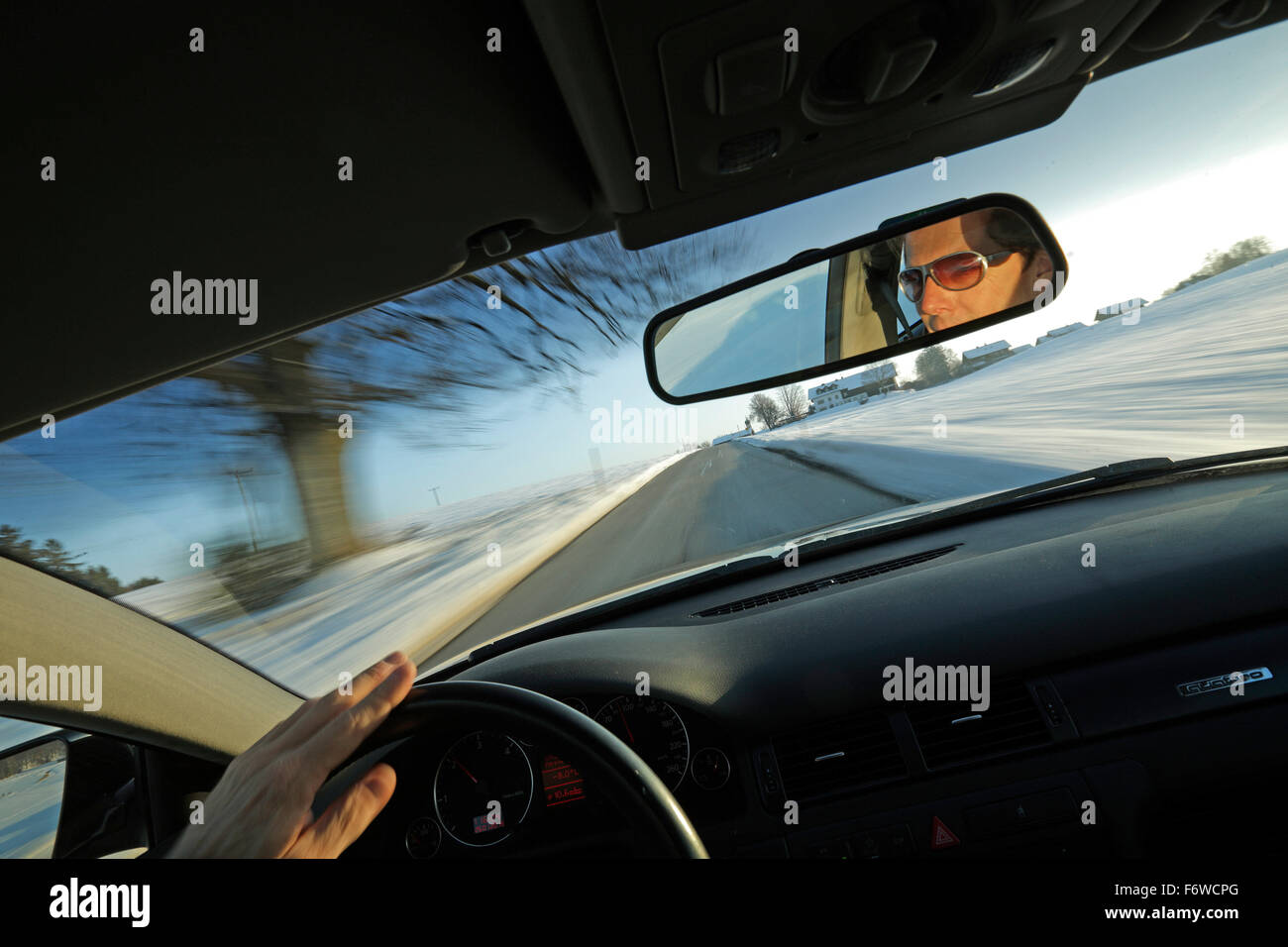 Man driving a car along a street in winter, Bavaria, Germany Stock ...