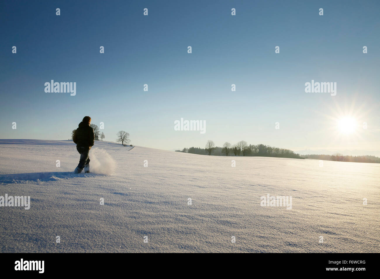 Man hiking through snow to Parish Church of St. John the Baptist ...