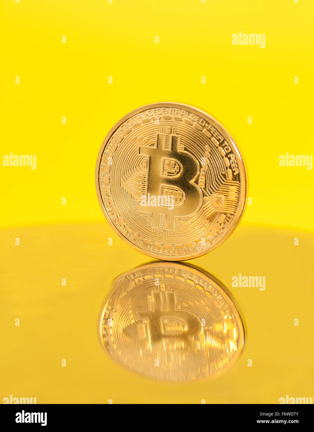 Golden Bitcoin coin on yellow background Stock Photo - Alamy