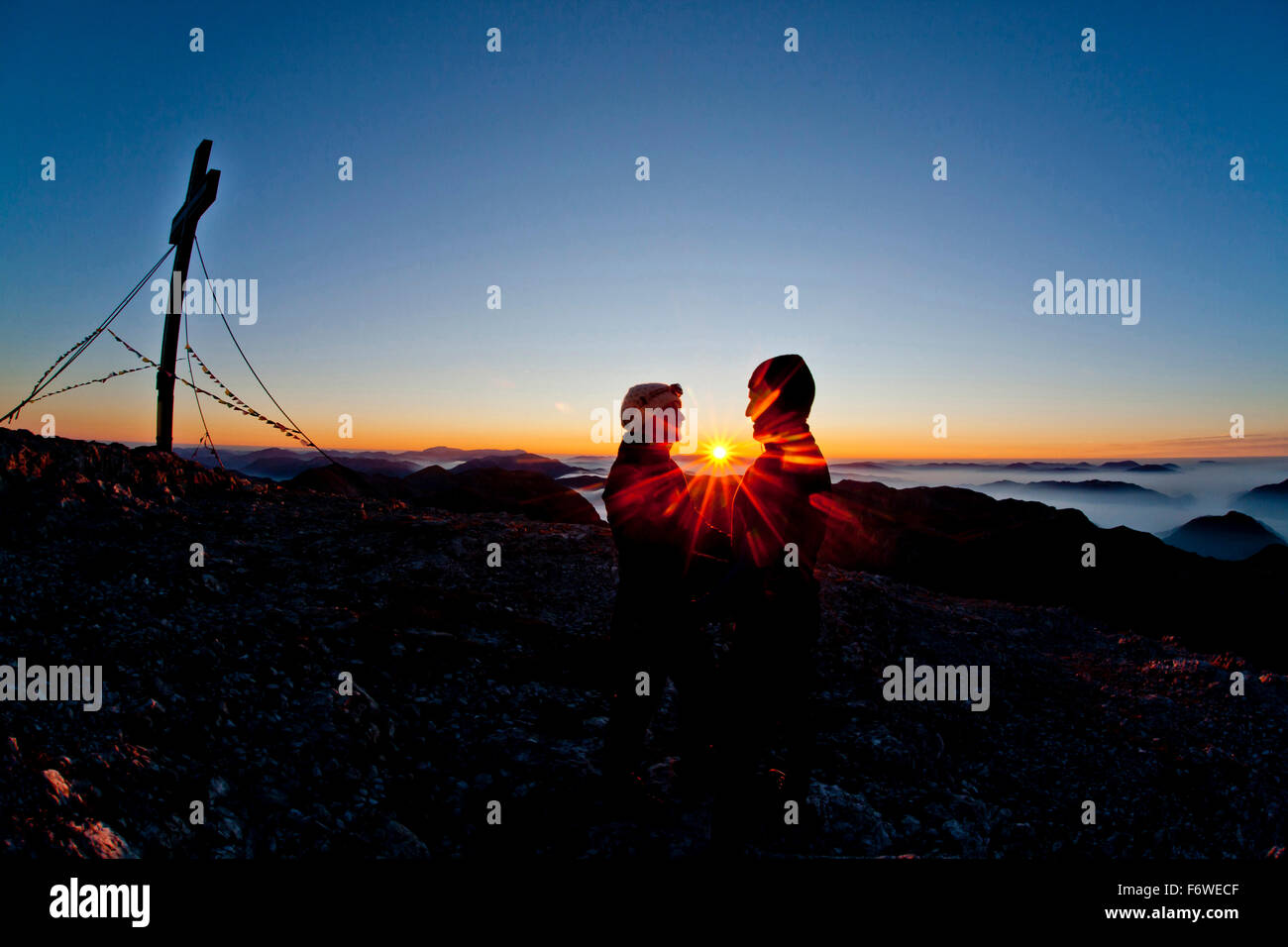 Two hikers at summit of Hochschwab mountain at sunrise, Hochschwab ...