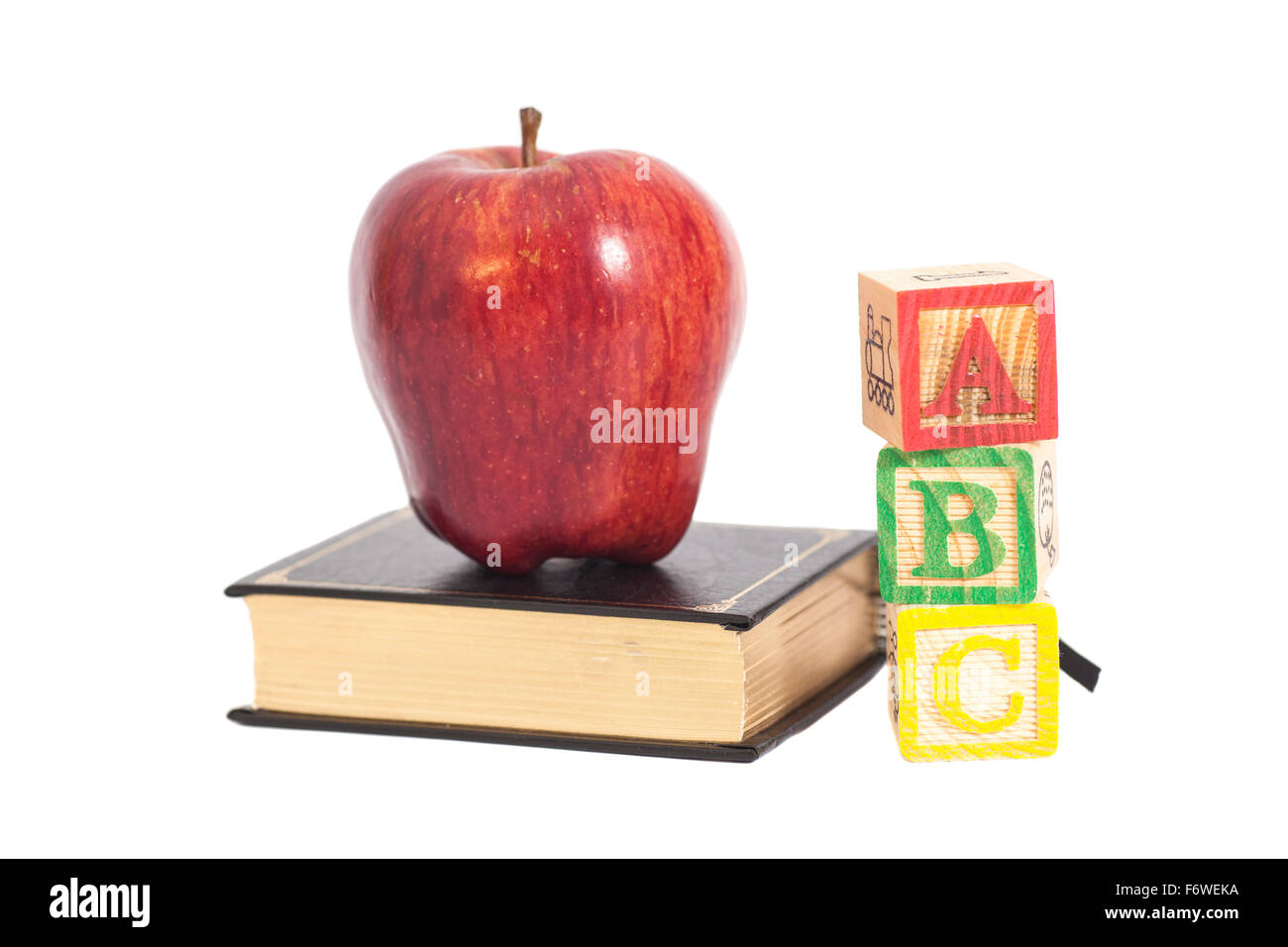 Red apple on book and ABC wooden letter blocks isolated Stock Photo - Alamy