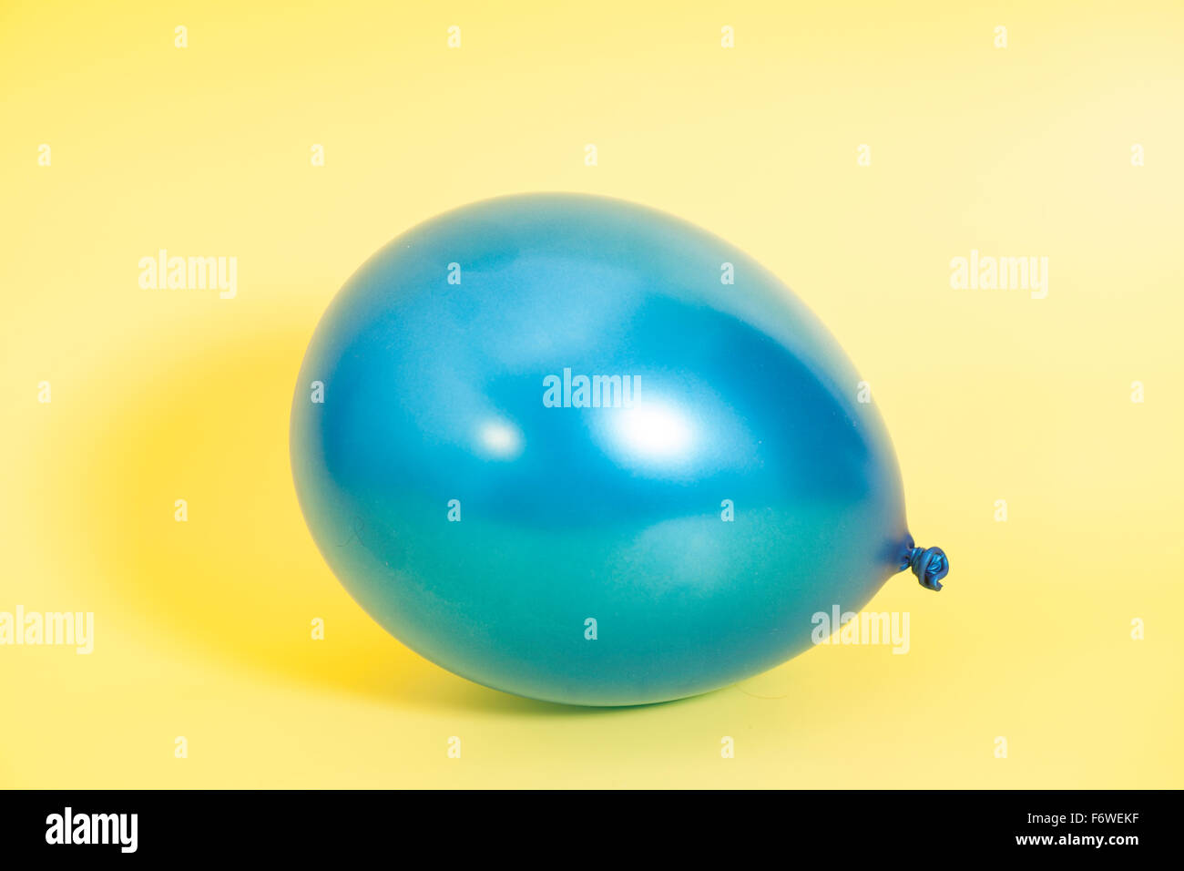 Blue Inflatable balloon on yellow background Stock Photo - Alamy