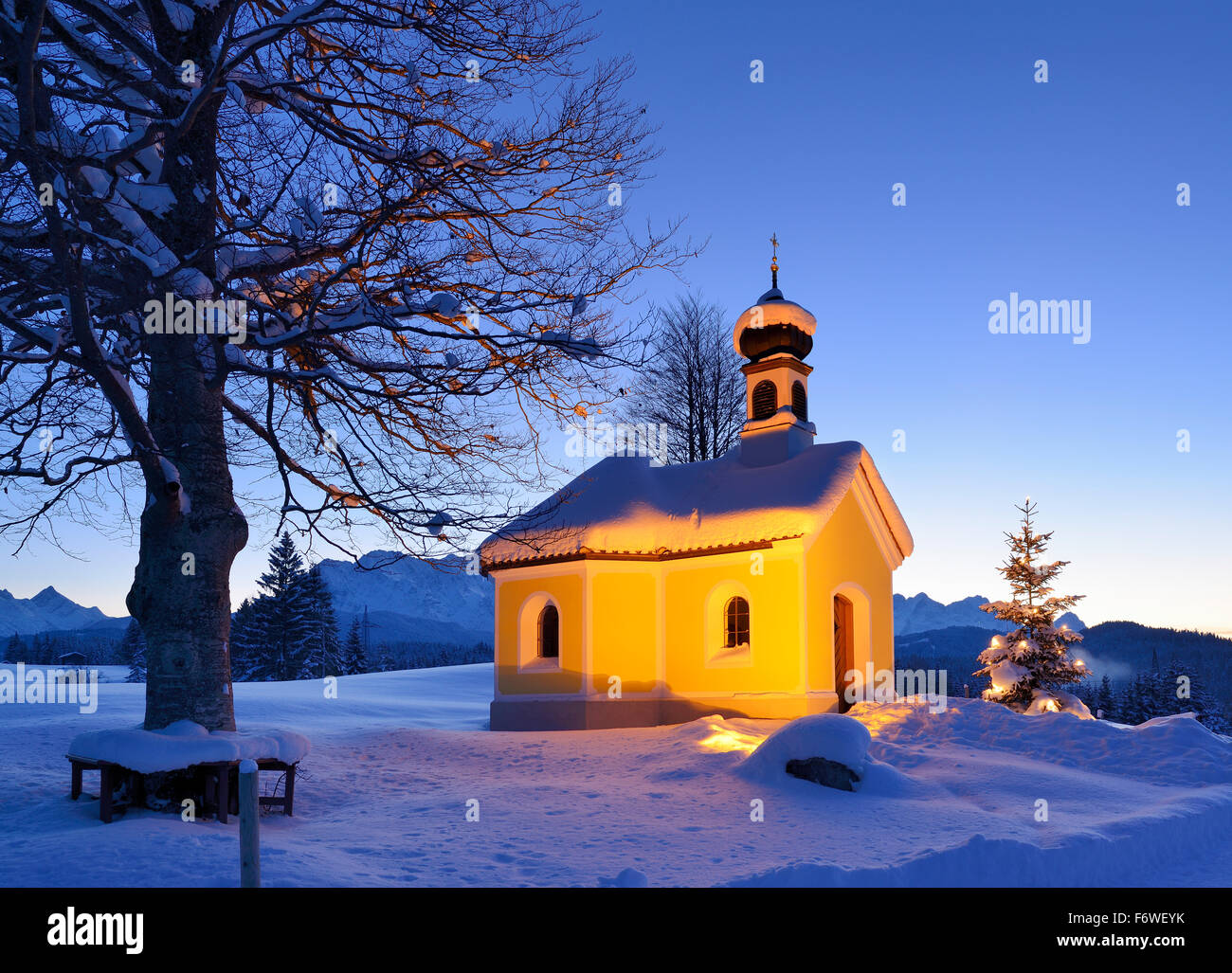 Snow-covered chapel with Christmas tree and Wetterstein range in ...
