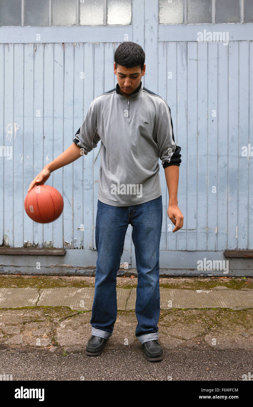 Youth bouncing a basketball Stock Photo - Alamy