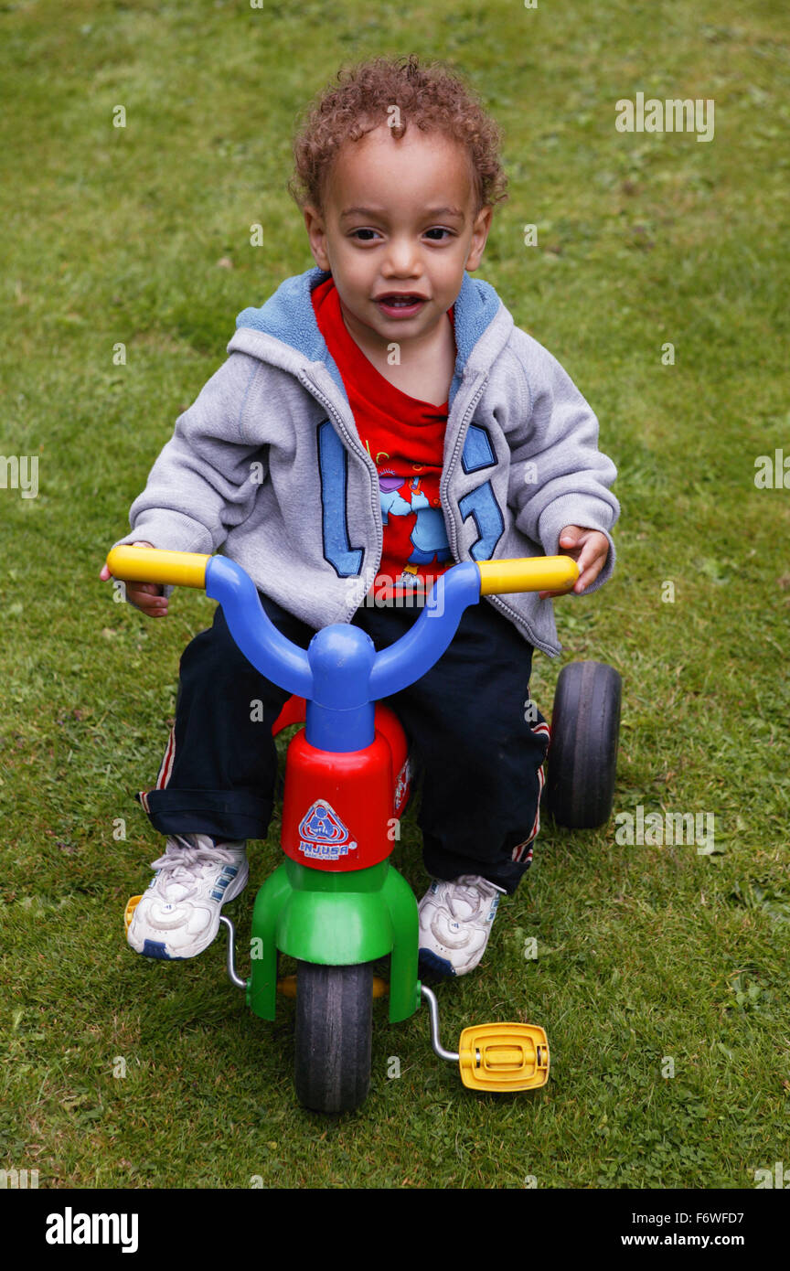 Young toddler in the garden on a tricycle Stock Photo - Alamy