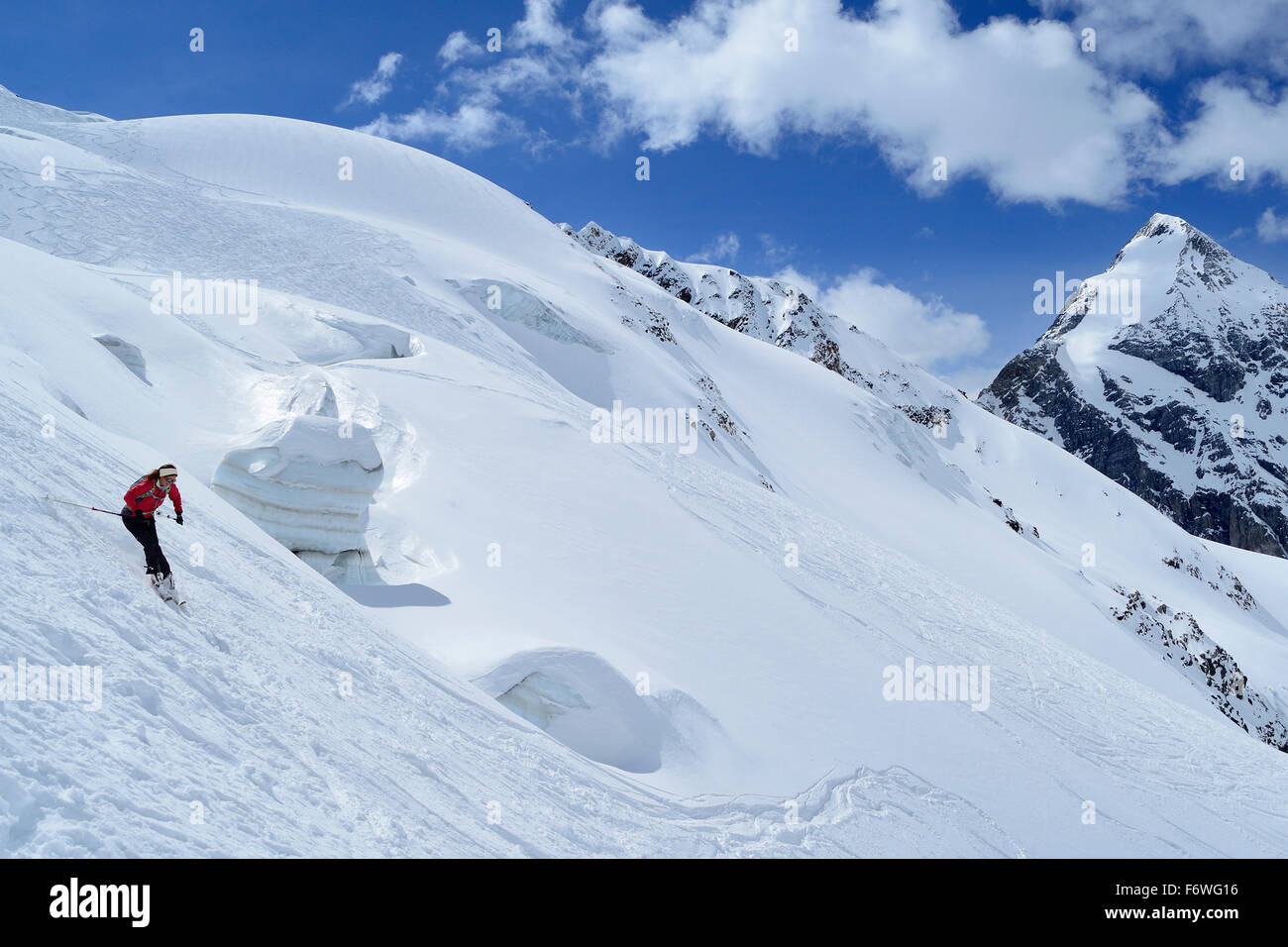 Female backcountry skier downhill skiing in front of Koenigspitze ...
