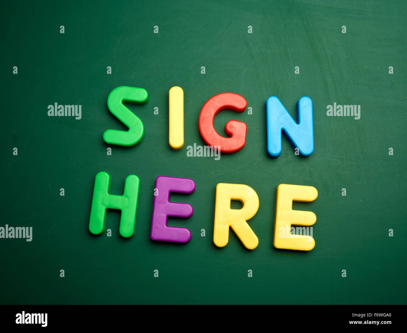 sign here concept in colorful letters isolated on blank blackboard ...