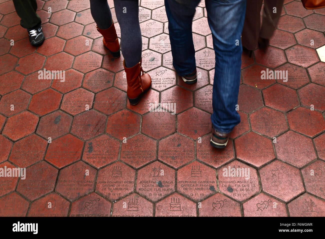 People walking over tiles with names of donors on paved pedestrian ...
