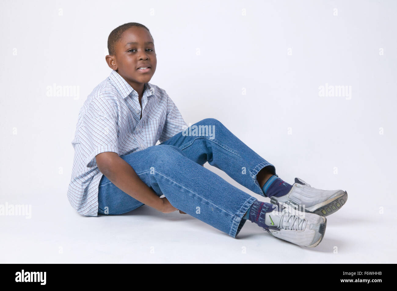 Young boy sitting on the floor smiling Stock Photo - Alamy